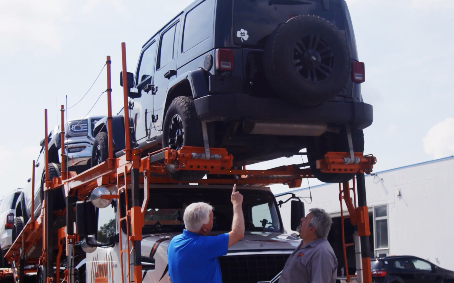 Two People Pointing at JMN Hauler - JMN Logistics & Transportation